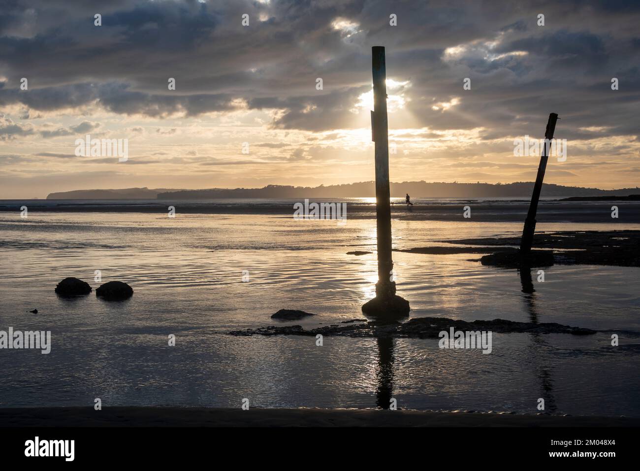Poles marking river mouth channel for boats entering the river, Orewa ...
