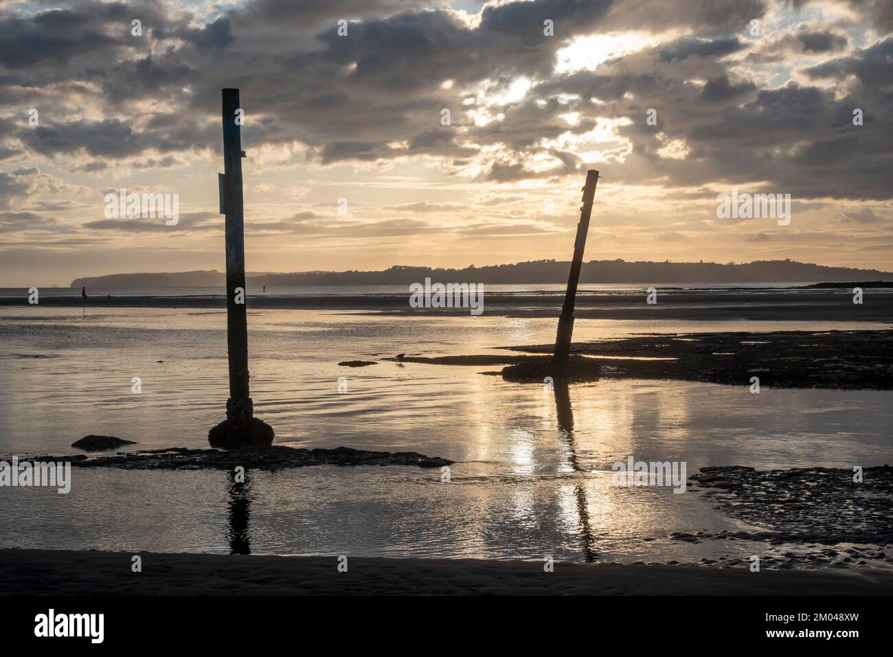 Poles marking river mouth channel for boats entering the river, Orewa ...