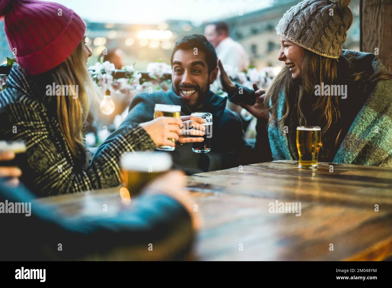 Young people having fun drinking beer at pub restaurant - Focus on ...