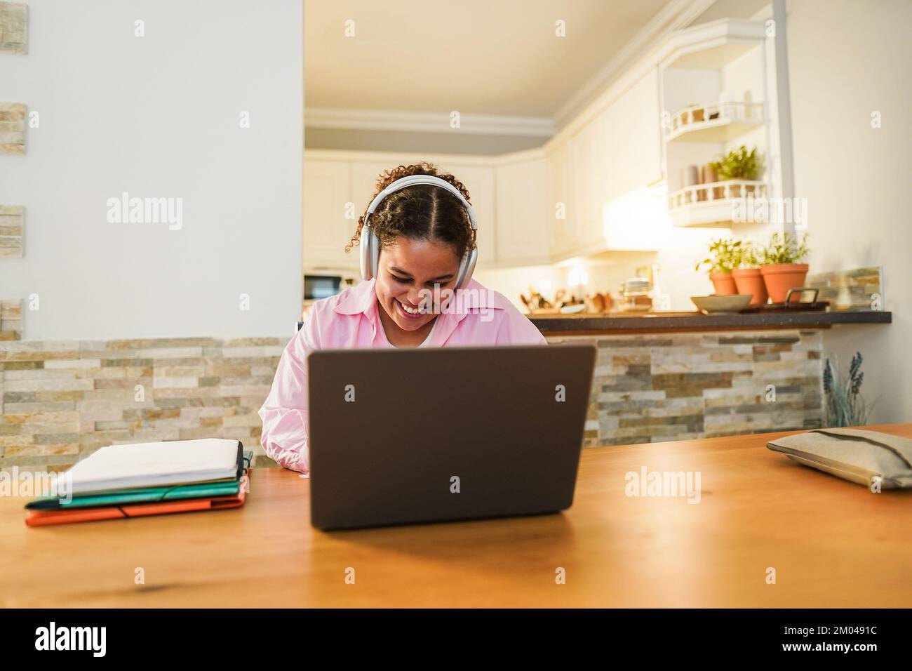 African girl using laptop computer at home while working on school project - Focus on face Stock ...