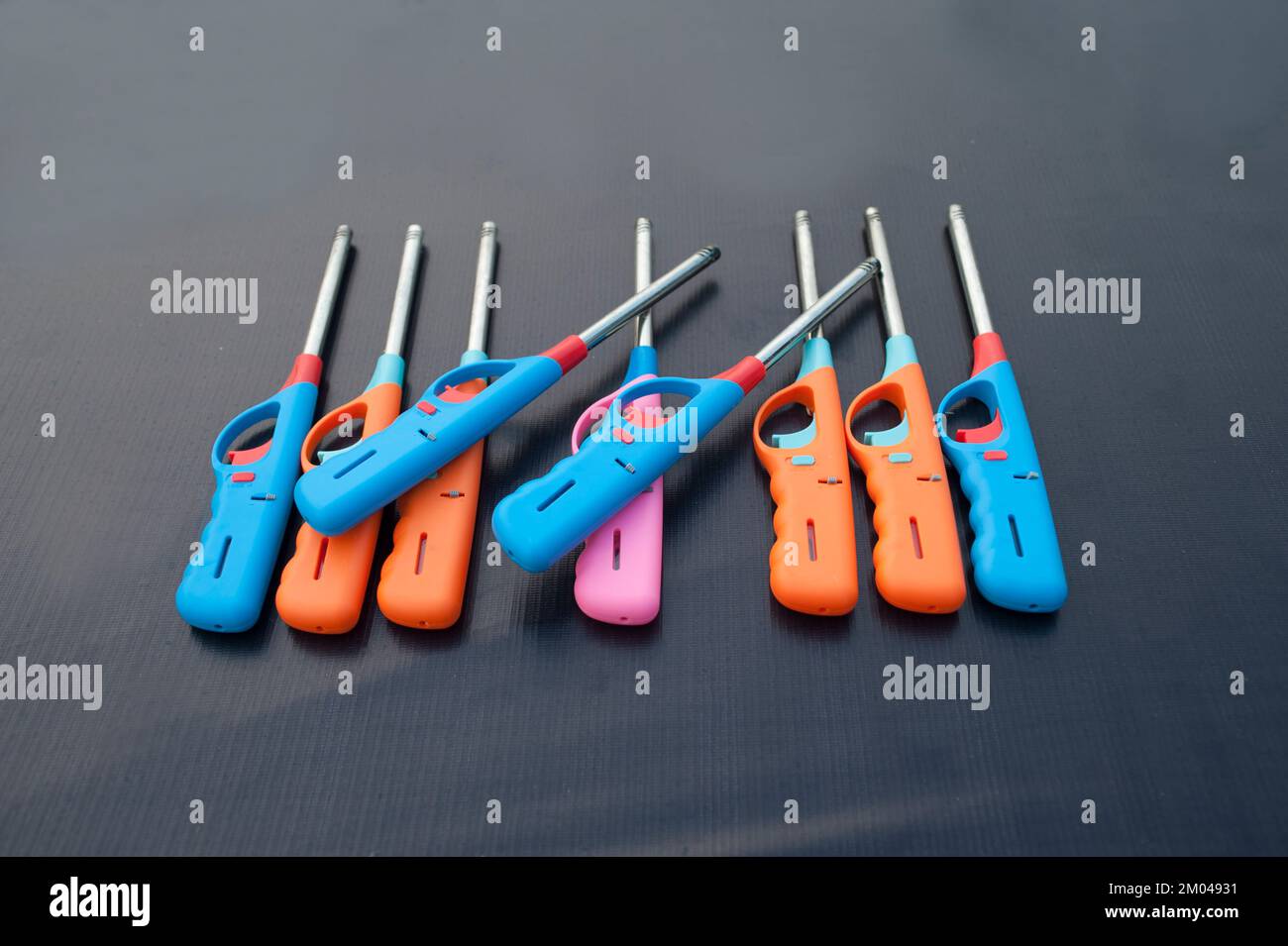 Group of colorful Gas lighter gun for gas-stove on a black background ...