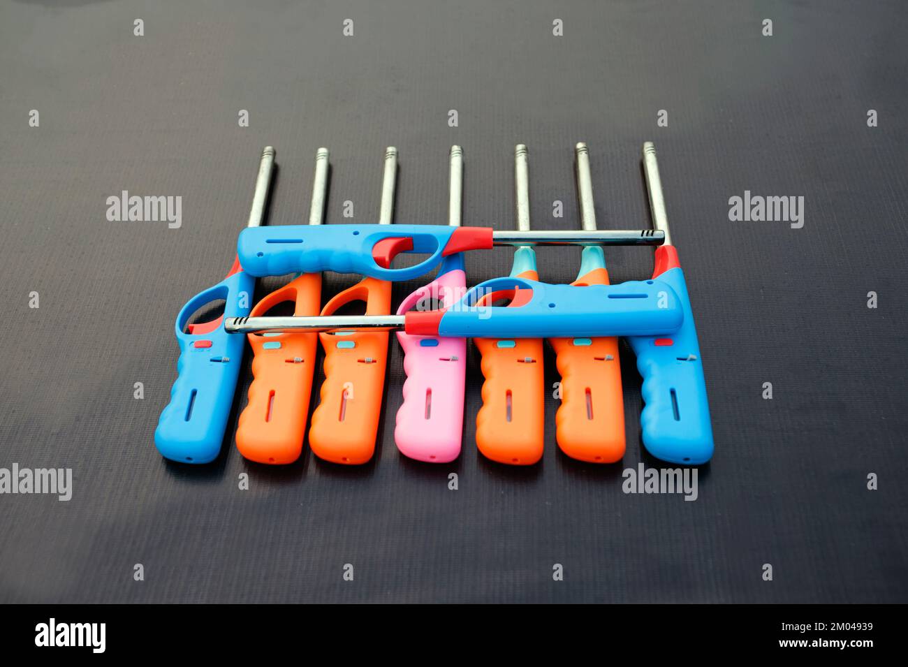 Group of colorful Gas lighter gun for gas-stove on a black background ...