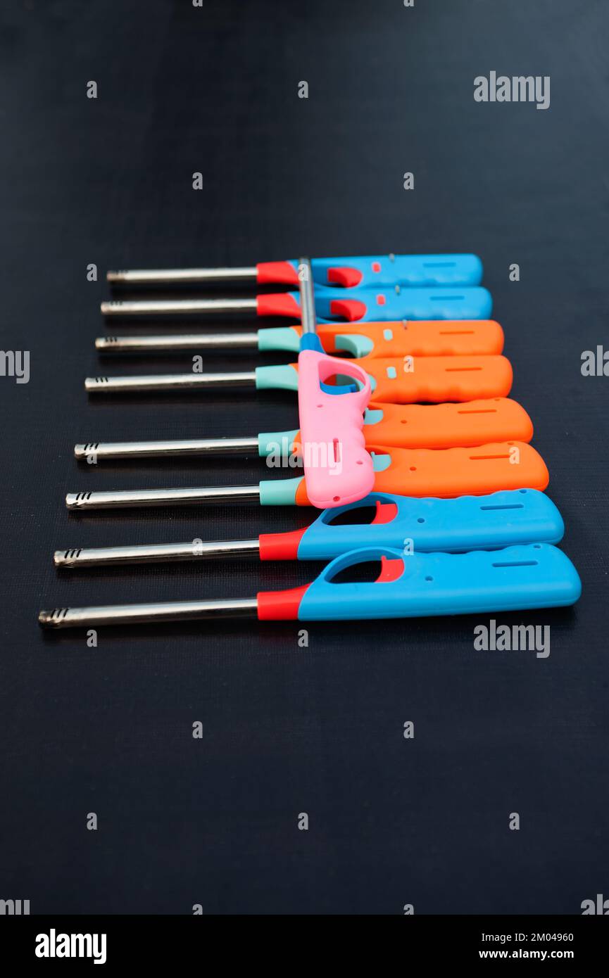 Group of colorful Gas lighter gun for gas-stove on a black background ...