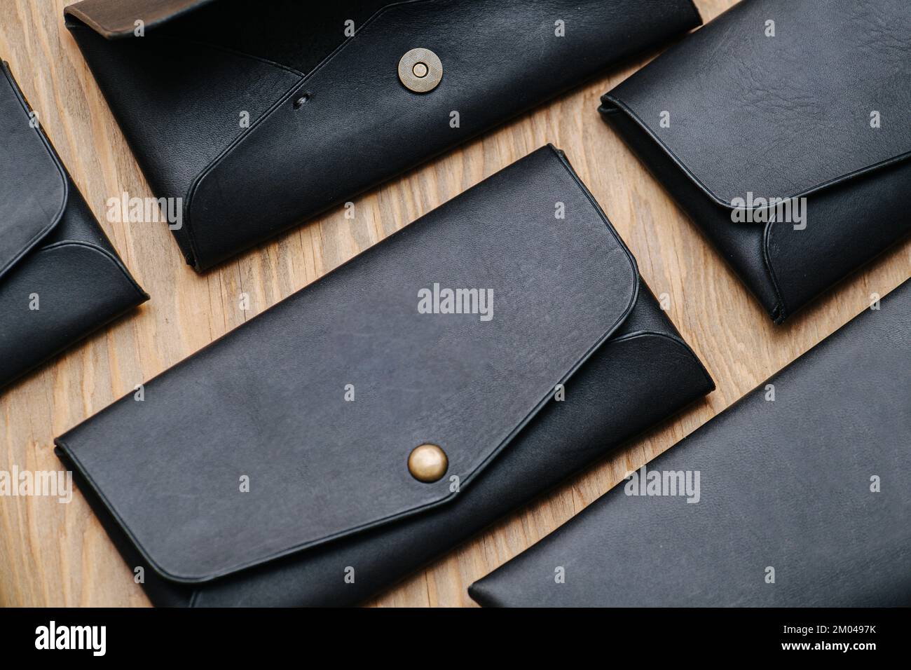 Black faux leather purses with clip buttons. Flat lay top view close up ...