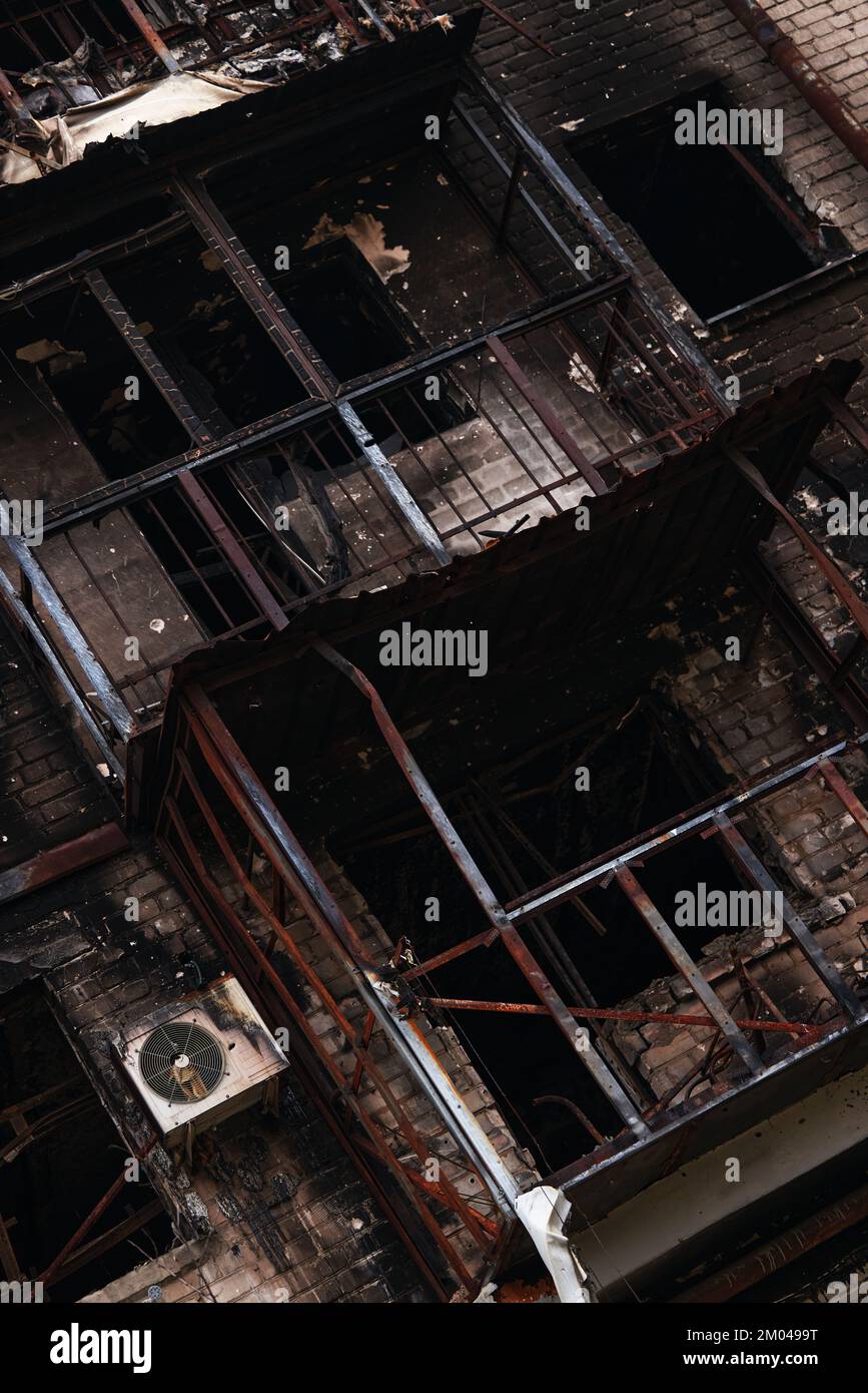 A burnt-out high-rise in the war zone. Damage to a residential building ...