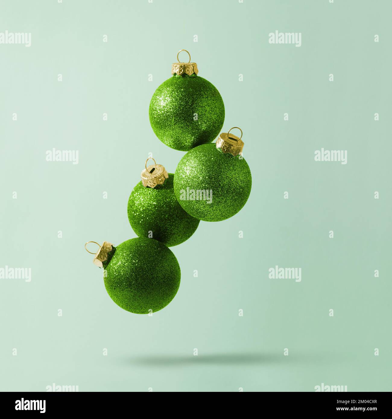 Green Christmas baubles levitating, on green background; Minimal ...