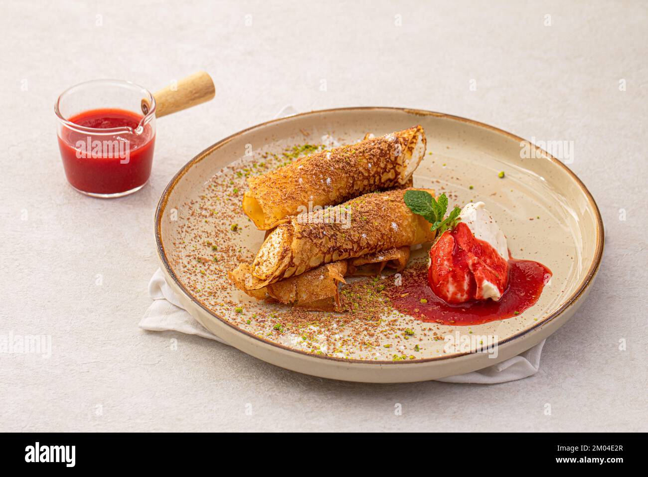 Sweet crepe roll with cream and jam Stock Photo - Alamy