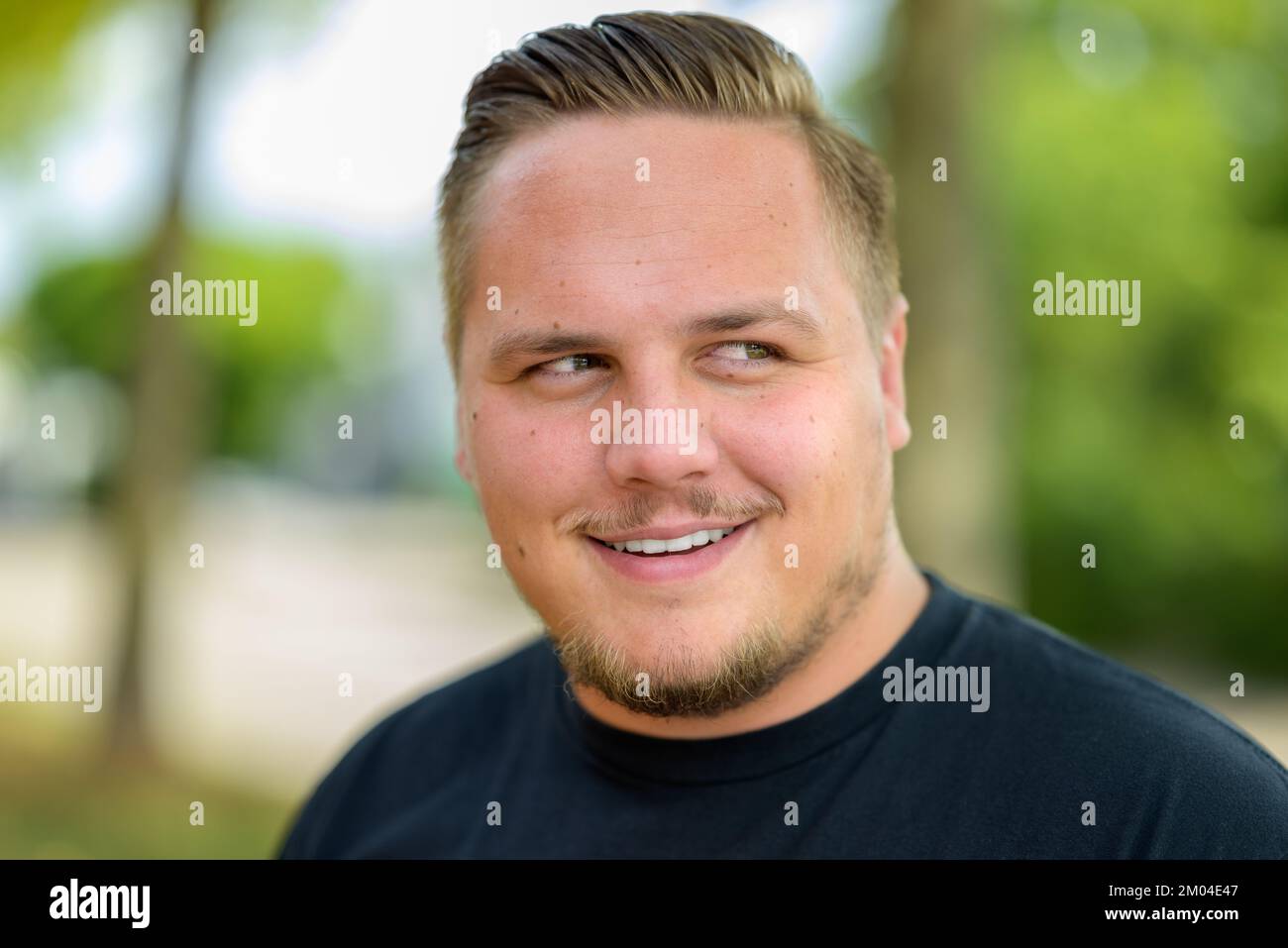 Happy smile young man looking aside with a knowing expression in a ...