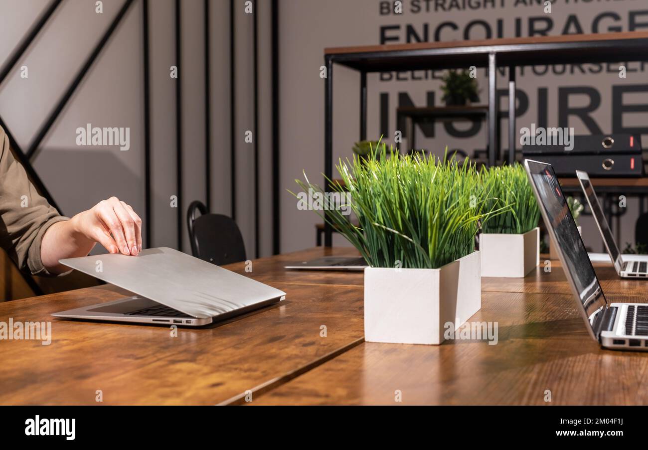 End of workday, finishing work in office concept. Hand closing laptop ...