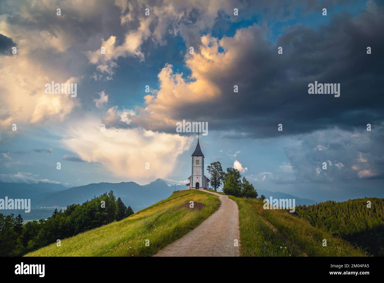 Rural landscape with small church on the mountain ridge. Cloudy scenery ...