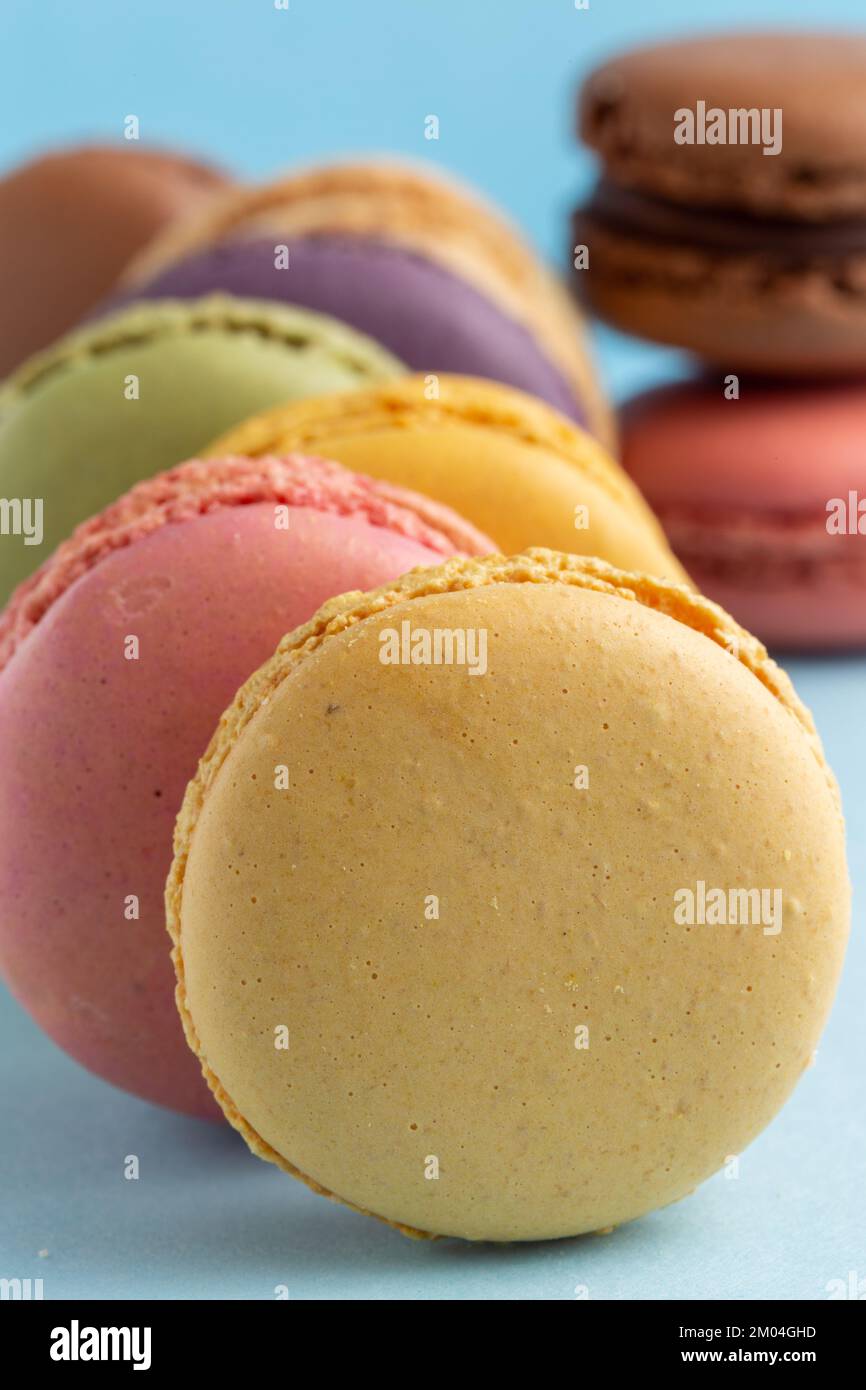 colored macaroons in a row on a blue background Stock Photo - Alamy