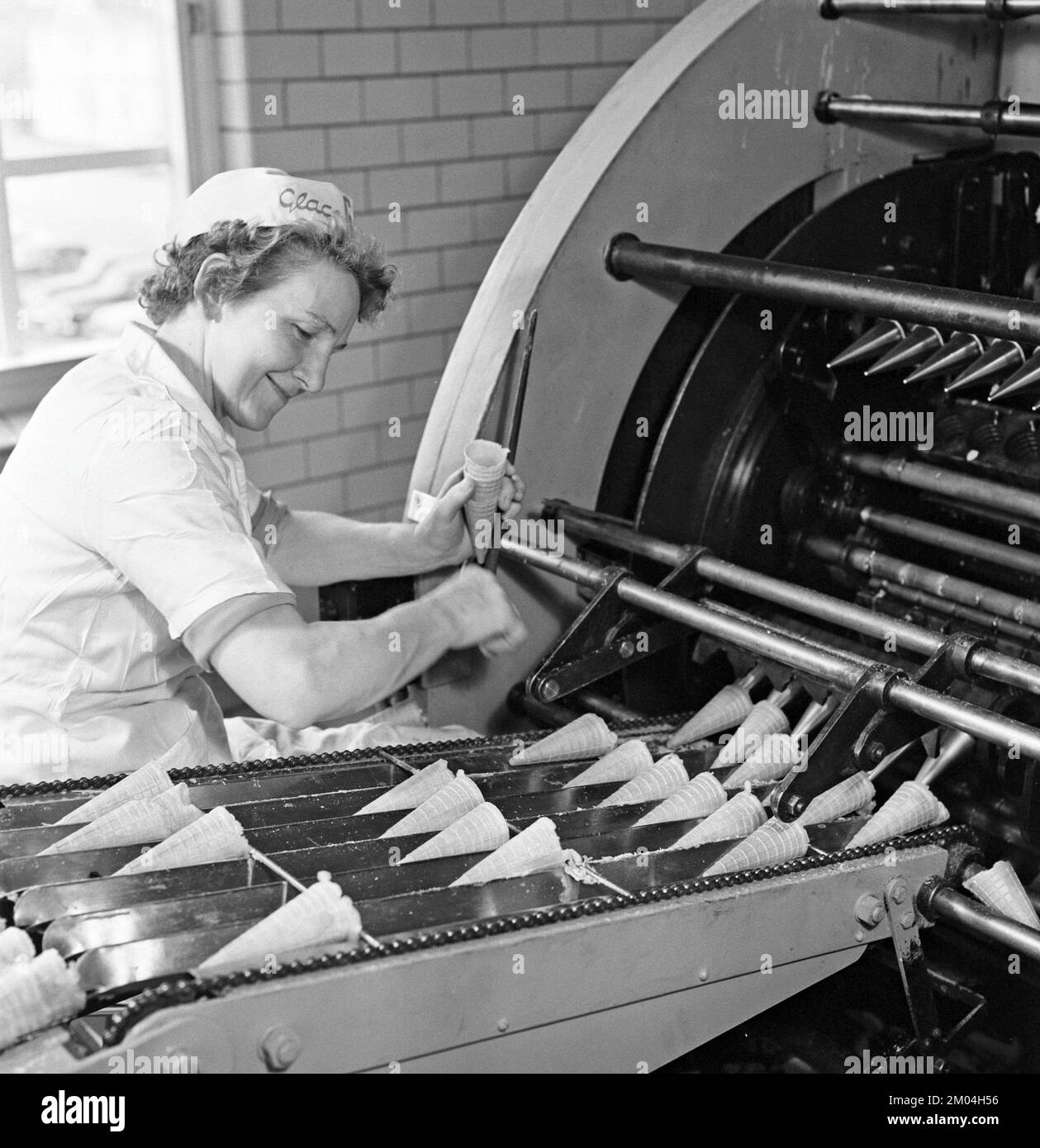 Ice Cream in the 1960s. Interior of a ice cream factory where a woman i ...