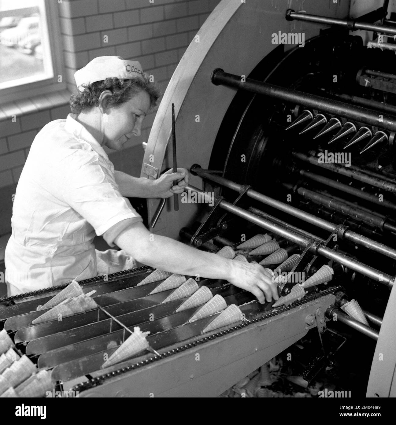 Ice Cream in the 1960s. Interior of a ice cream factory where a woman i ...