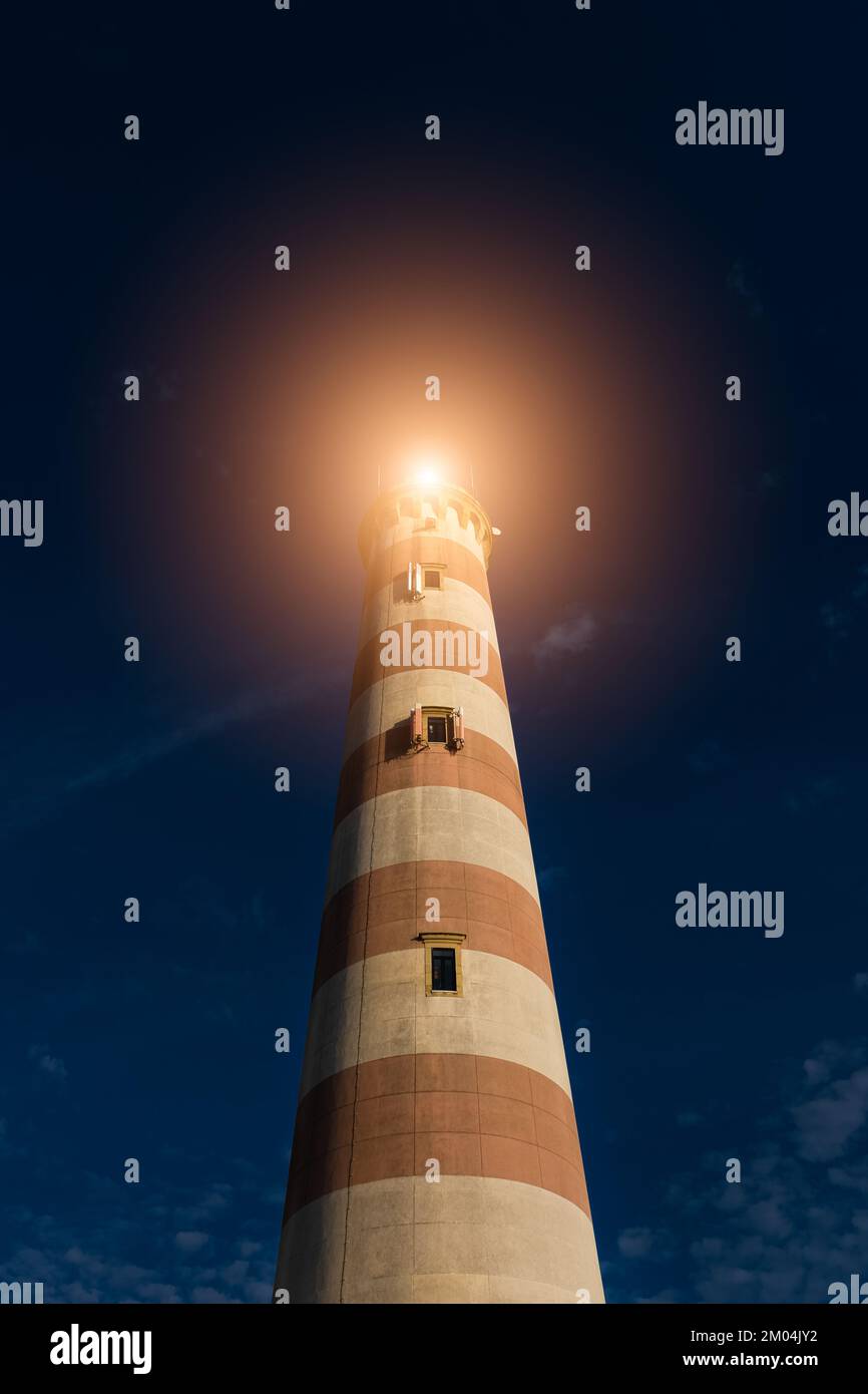 View of the old striped lighthouse beacon that shines brightly in the ...