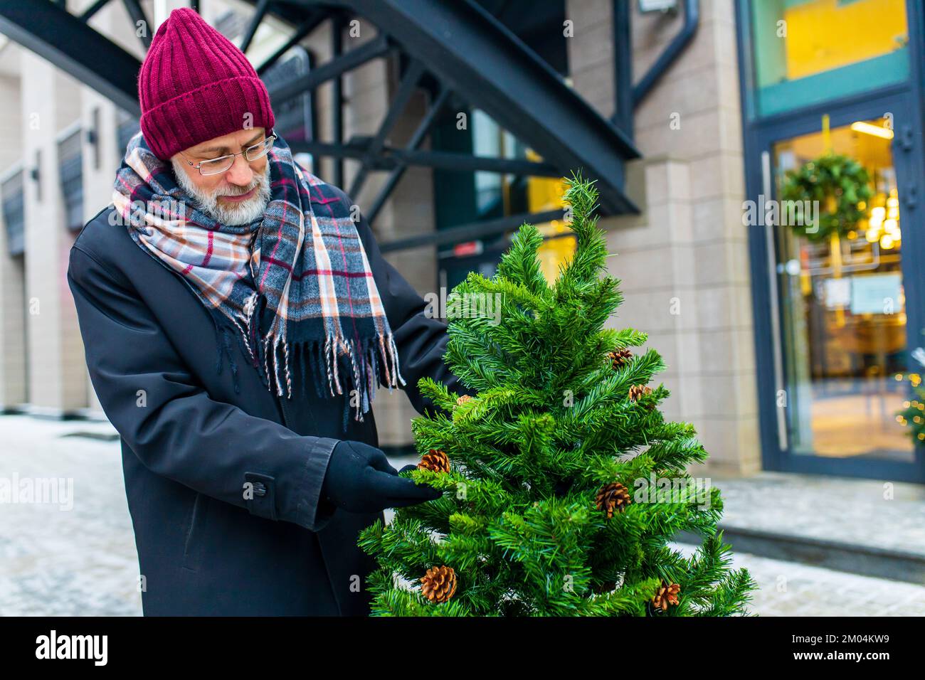 happy retired man walking by street with christmas tree to home from ...