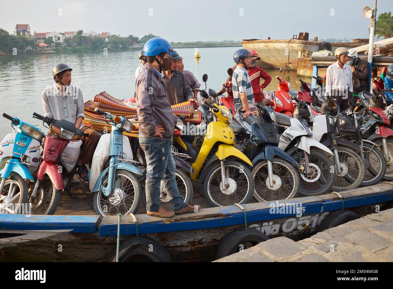 Cross river ferry arriving with boatload of passengers in in Hoi An ...