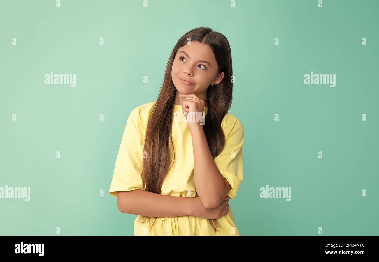 pondering teen girl with long hair on blue background, making decision ...