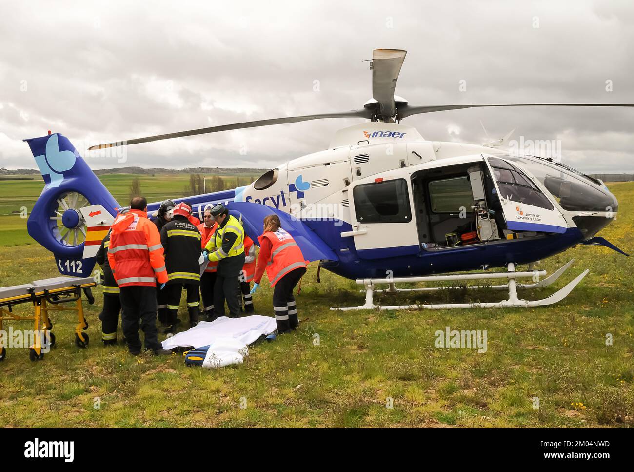 Emergency helicopter perched in the field next to paramedics and ...