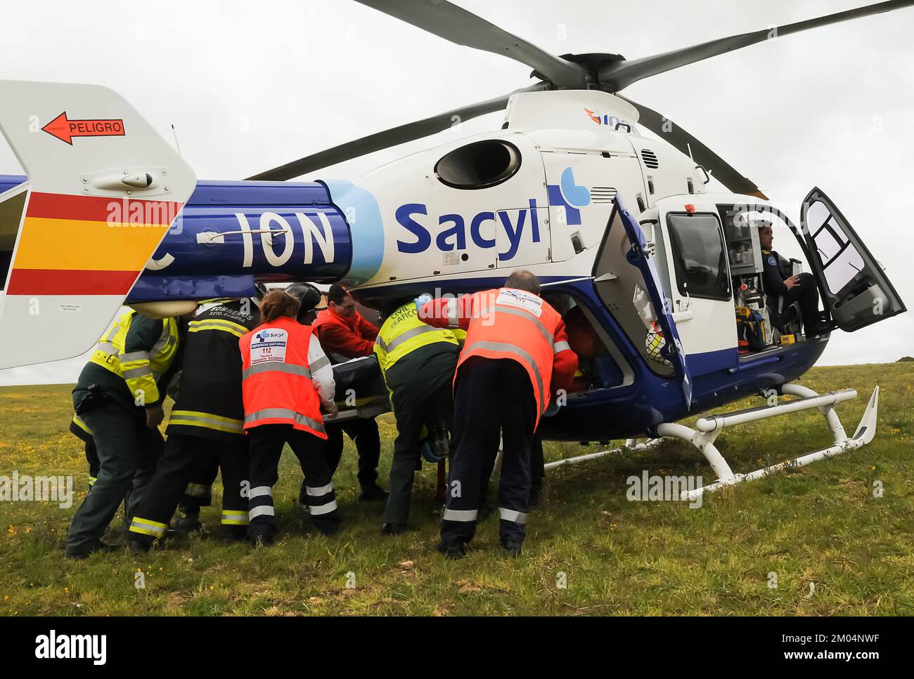 A helicopter is loaded with an injured person by a group of paramedics ...