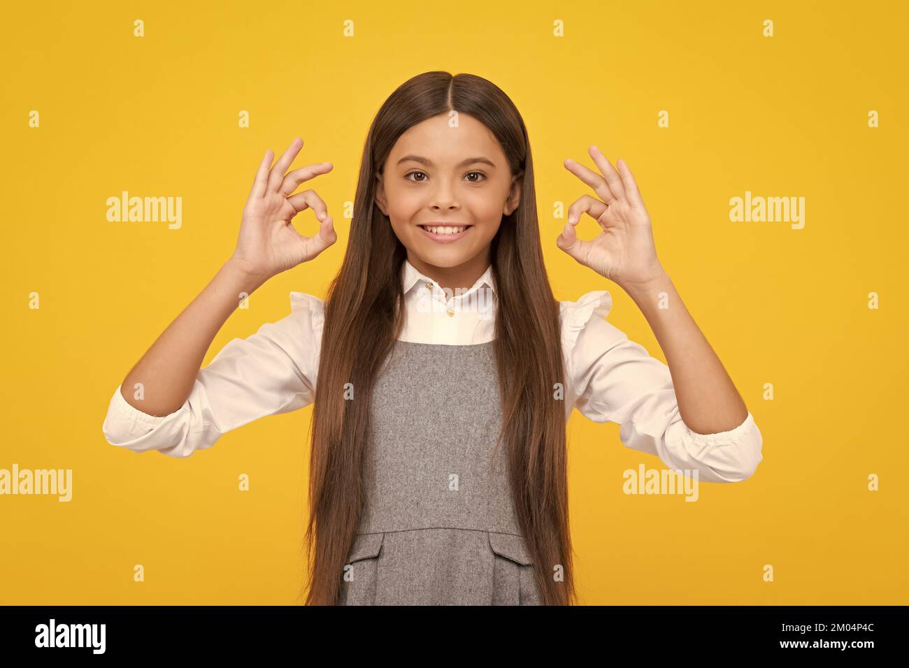 Cute teenager child girl making Ok gesture on yellow background. Happy ...