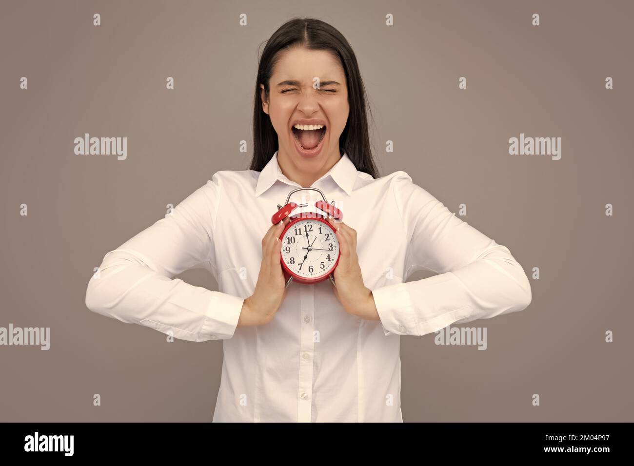 Woman holds a clock. Emotional young female face. Portrait of young ...