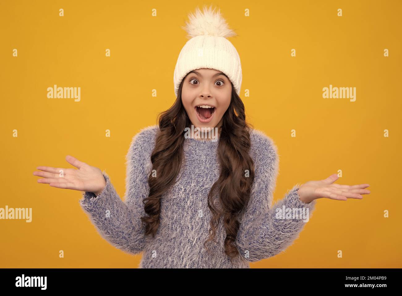 Teenager girl with winter hat over isolated yellow background. Winter ...