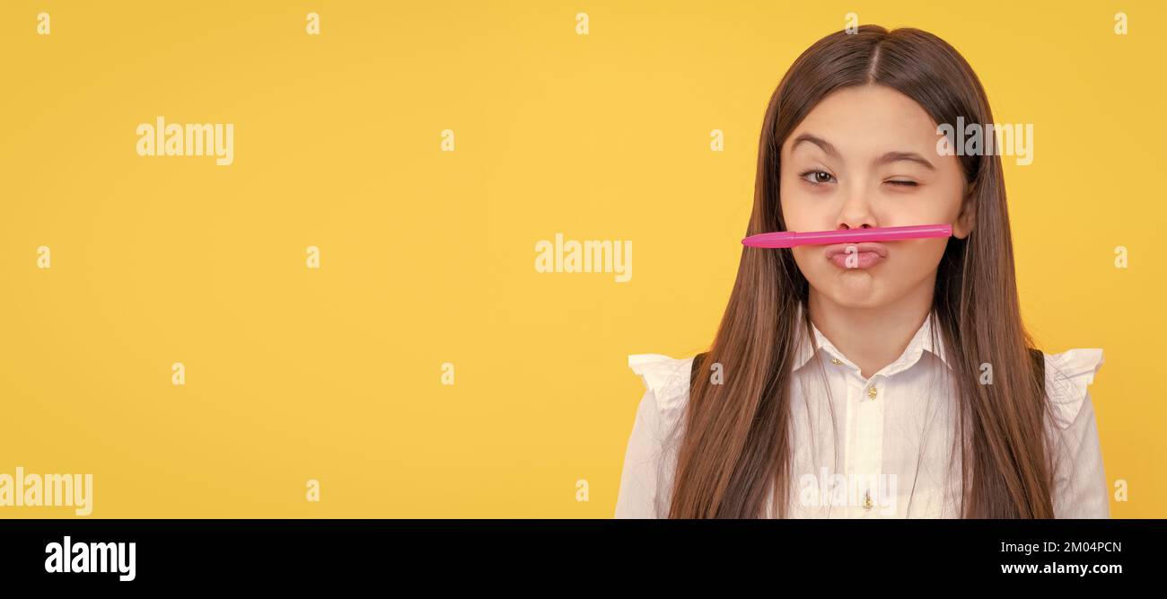 Playful winking girl child hold pen as mustache yellow background ...