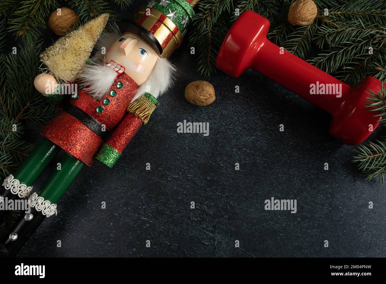 Gym dumbbell, Christmas nutcracker figure, walnuts and tree branches ...
