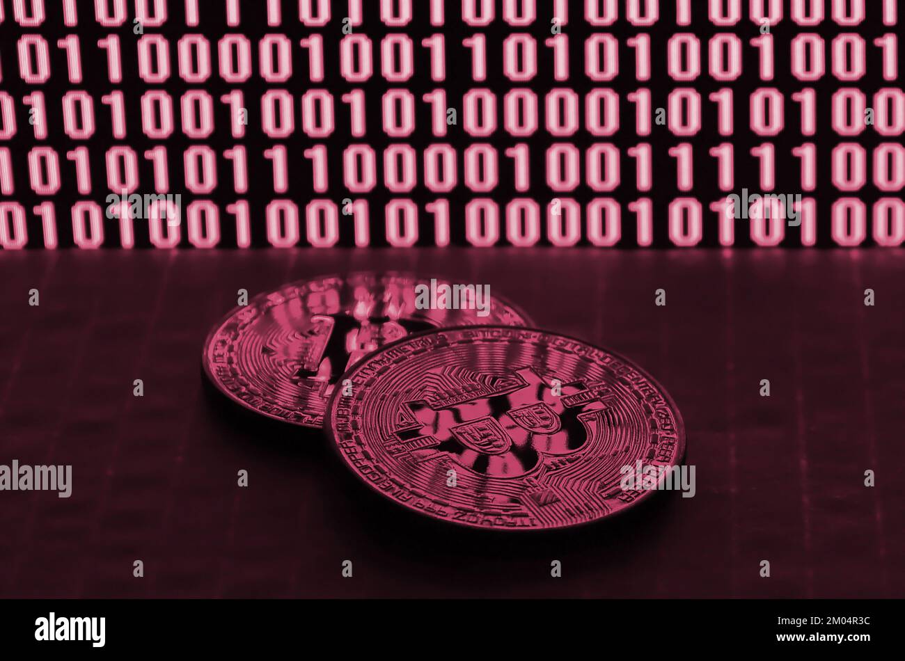 A pair of bitcoins lies on a cardboard surface on the background of a ...