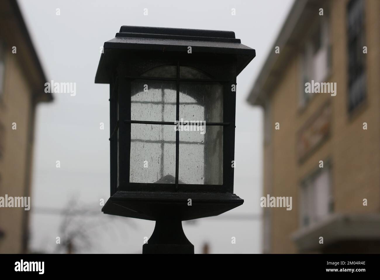Traditional box iron metal street lamp on a cloudy day Stock Photo - Alamy