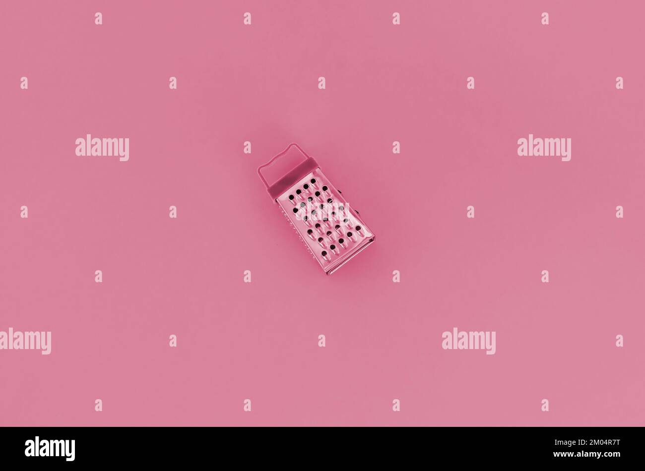 Stainless steel grater lies on a paper. Kitchen accessories. Tools for ...