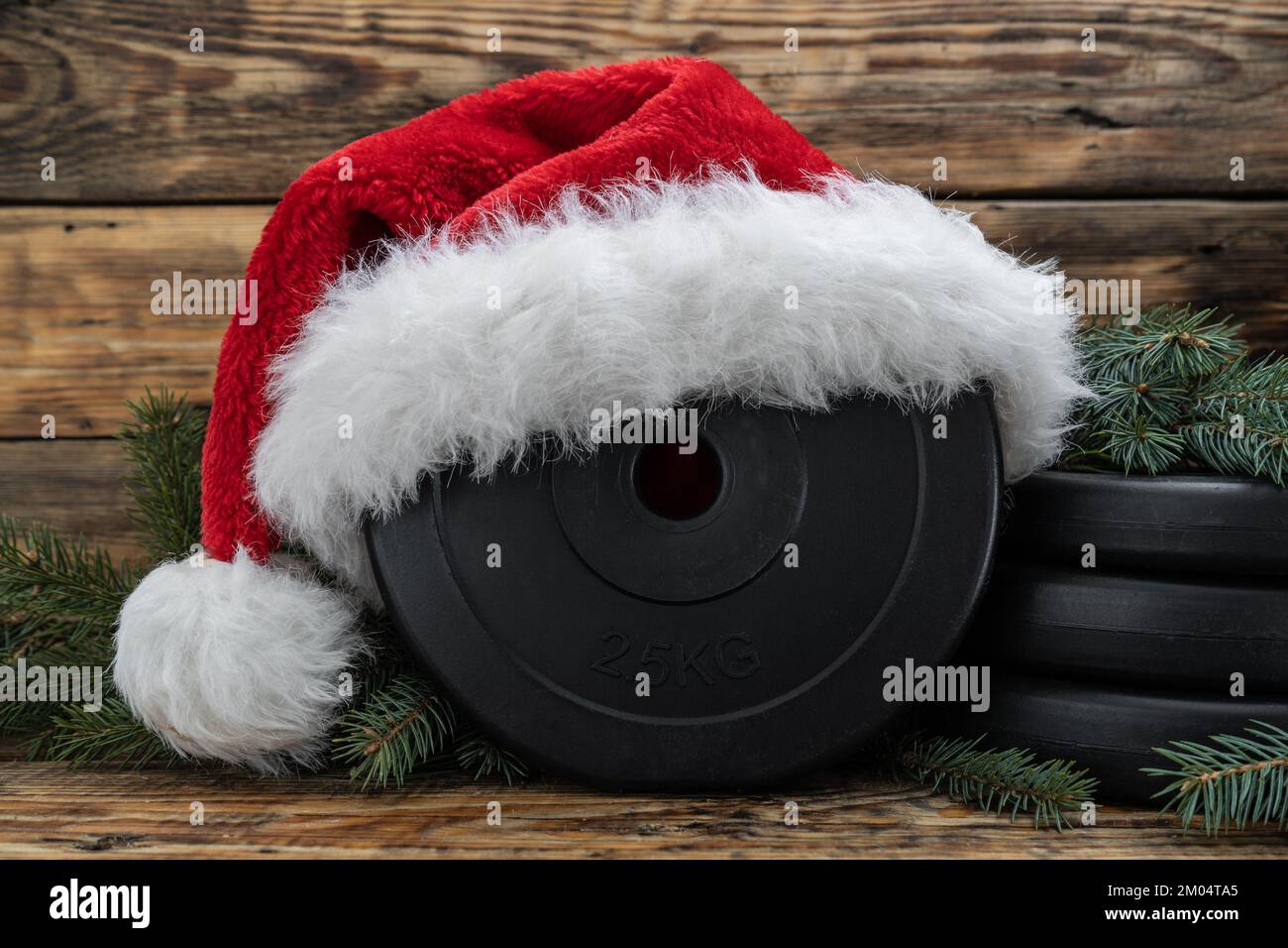 Gym dumbbell barbell weight plate disc in red Santa Claus hat and ...