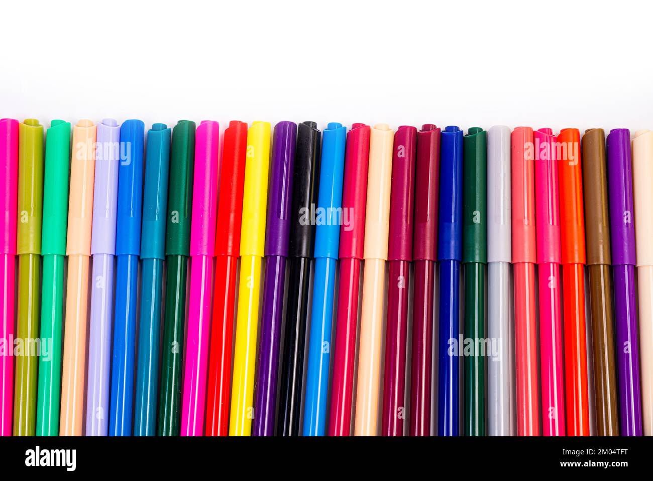 A set of multi-colored felt-tip pens in a row, rainbow on a light white ...