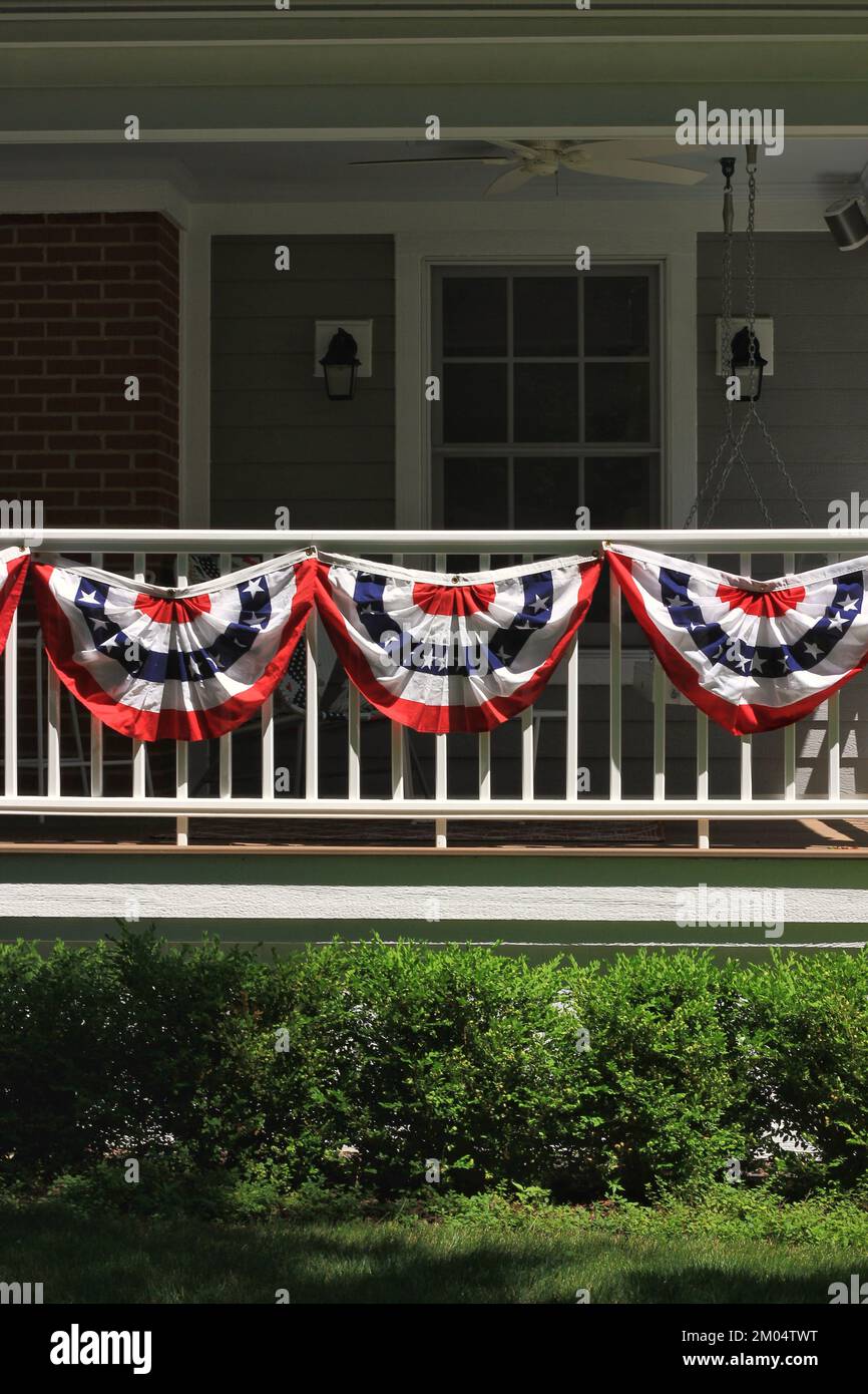 A typical Fourth of July banner hanging from a traditional wooden front ...