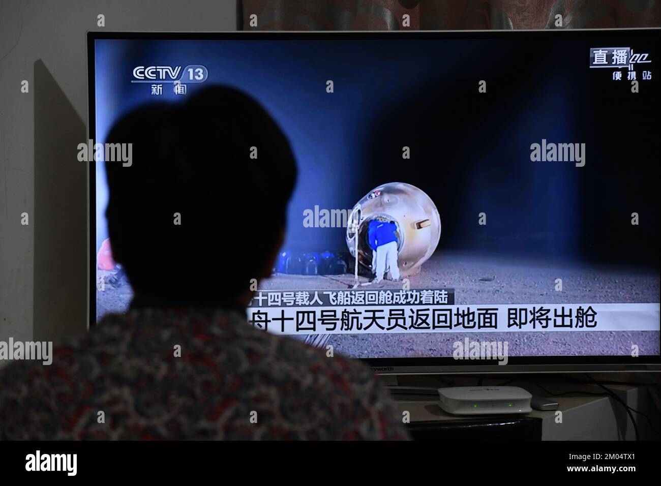 FUYANG, CHINA - DECEMBER 4, 2022 - Citizens watch a live TV broadcast ...