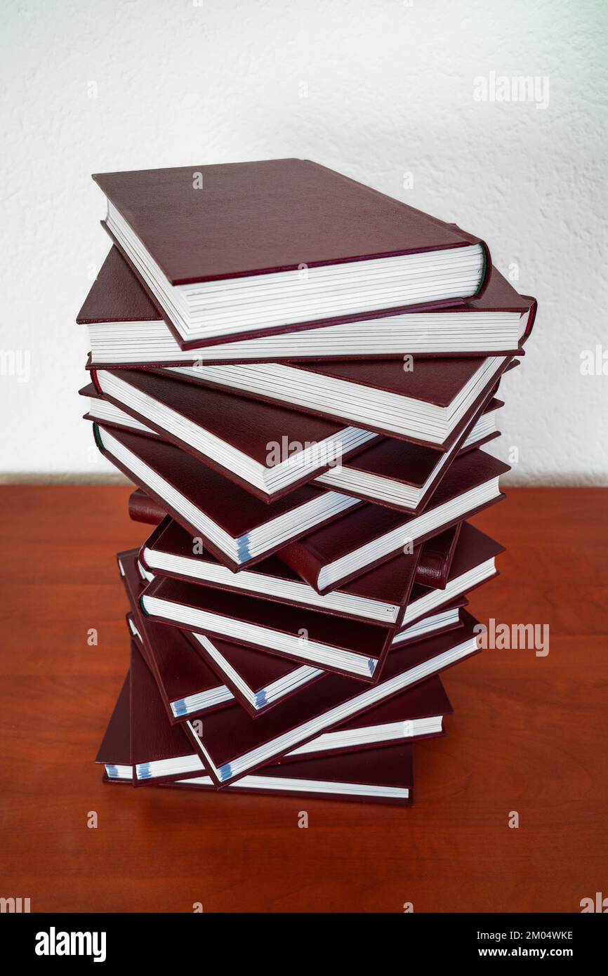 A pile of books wooden shelf and a white wall in the background Stock ...