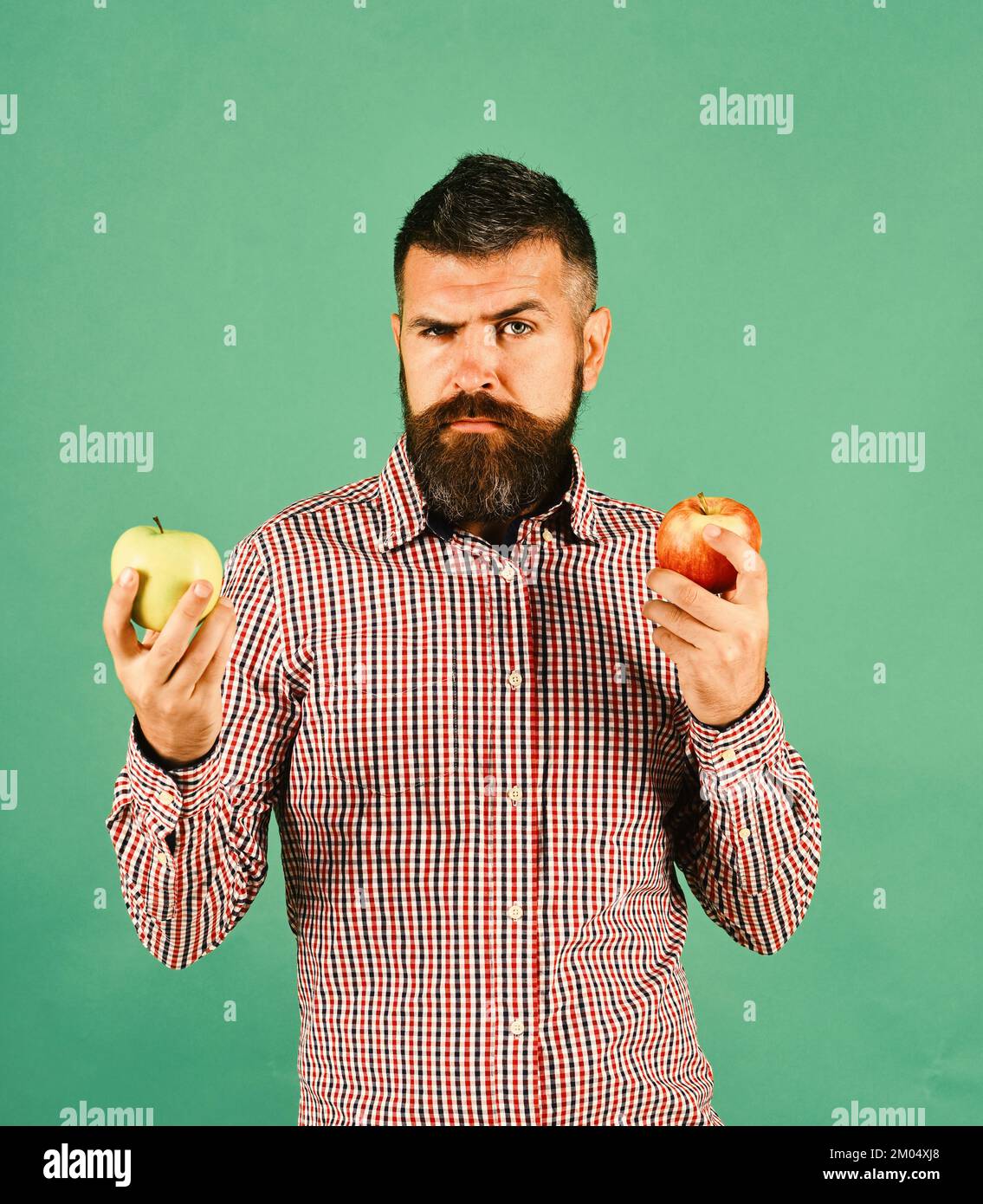 Man with beard holds red and green apples Stock Photo - Alamy