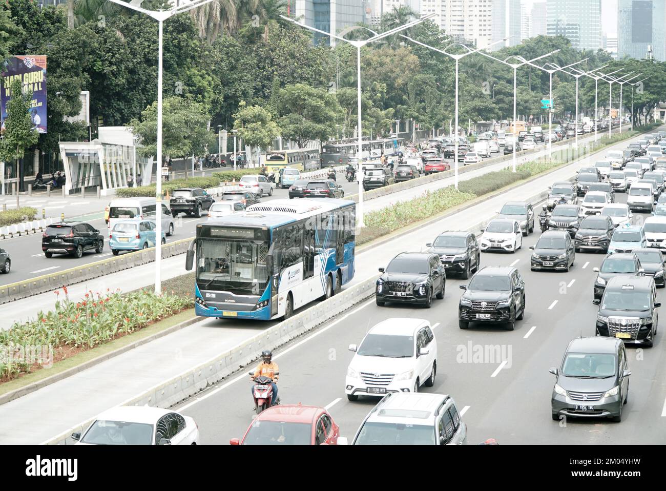 Trans Jakarta bus in bus way line, at the rush hour traffic. Location in business district ...