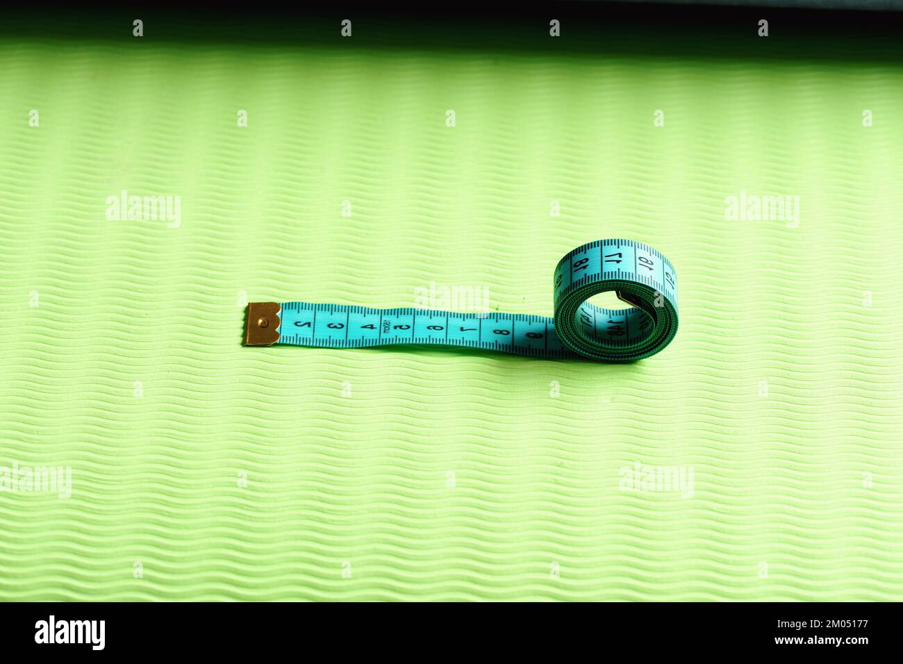 Measuring tape roll in cyan color on green texture background Stock ...