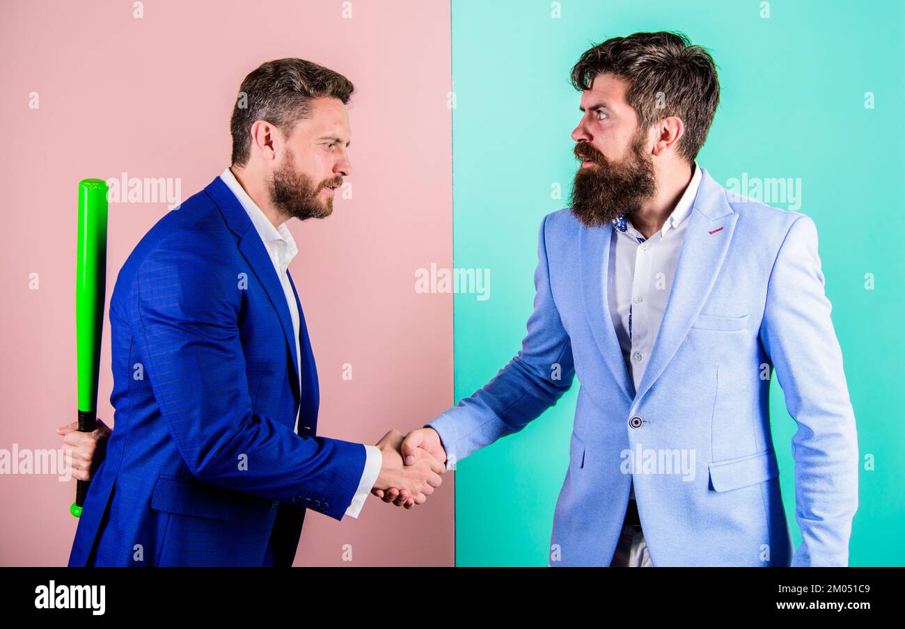 Do not trust him. Businessman hides bat behind back while shaking hands ...