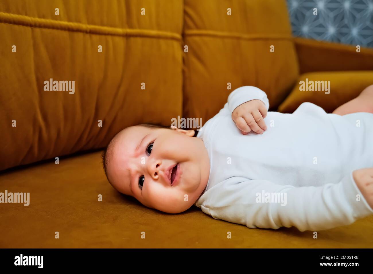 newborn baby lies on the dewan. newborn baby shows different emotions ...
