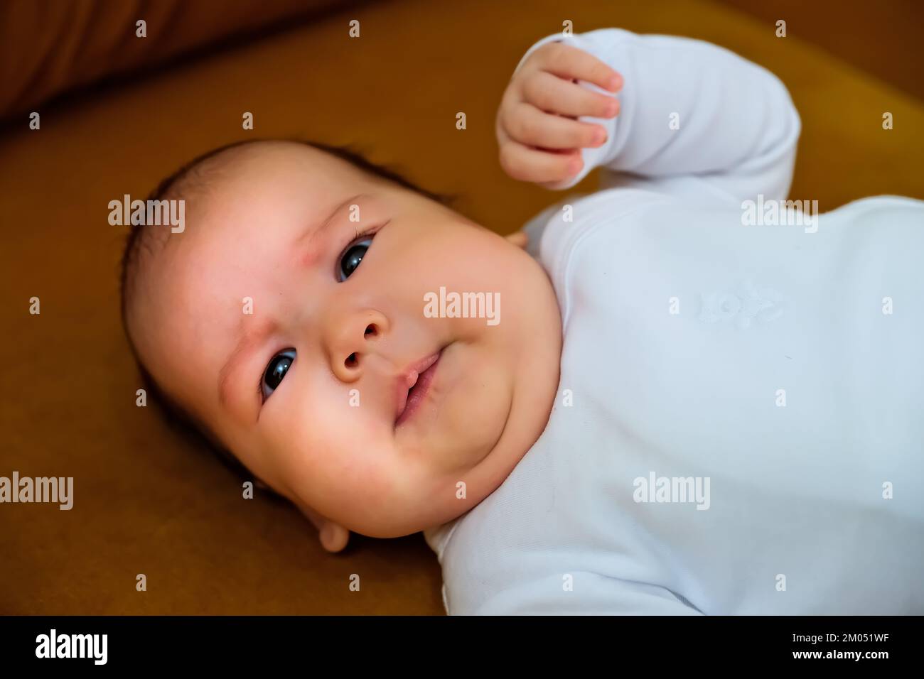newborn baby lies on the dewan. newborn baby shows different emotions ...