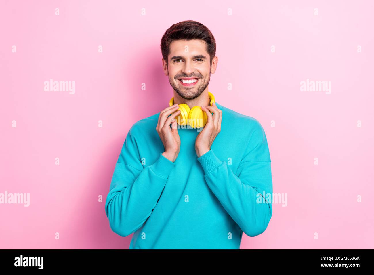 Photo portrait of handsome young man touch earphones excited beaming ...
