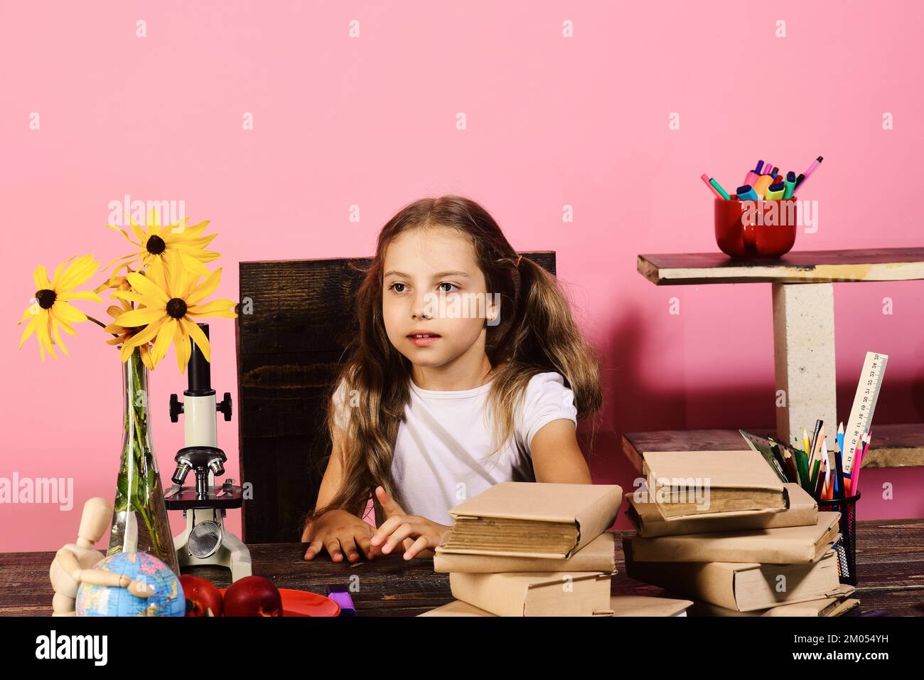Kid and school supplies on pink wall background Stock Photo - Alamy