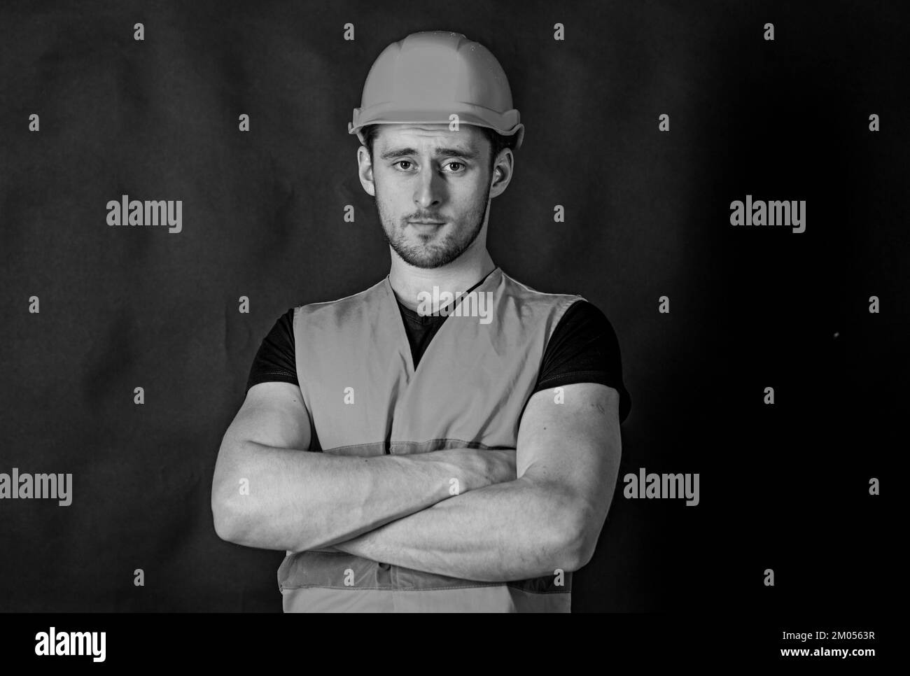 Man in helmet, hard hat hold arms crossed on chest, black background ...