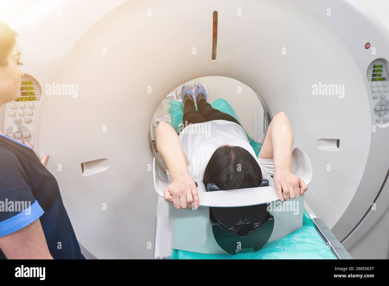 A woman lies on the tomograph table. woman is undergoing computed axial tomography examination ...