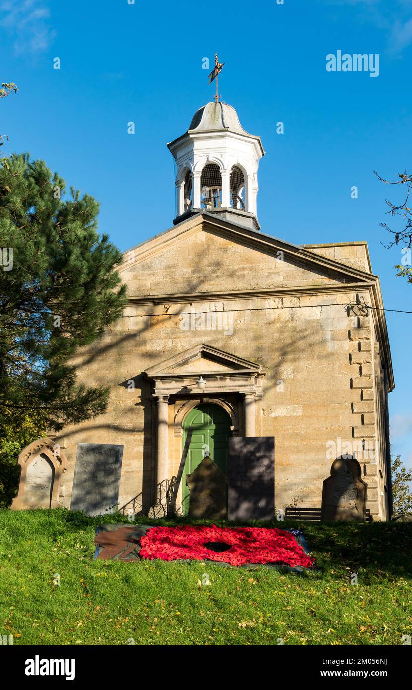 Bed of hand knitted poppies in front of church commemorating poppy day ...