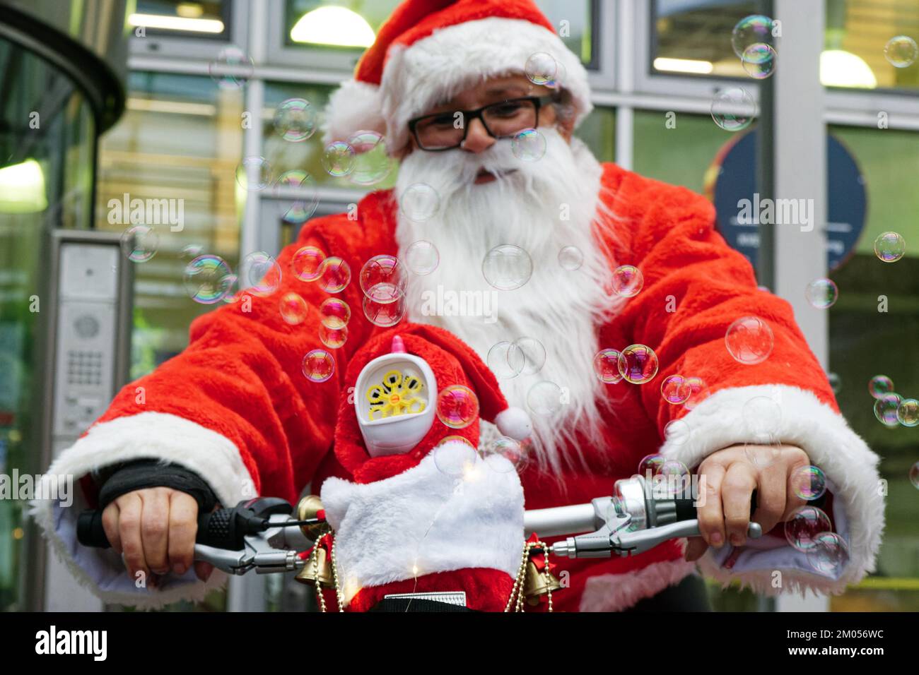 Cologne, Germany. 04th Dec, 2022. A cyclist dressed as Santa Claus lets ...