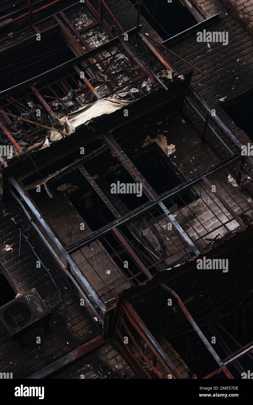 A burnt-out high-rise in the war zone. Damage to a residential building ...