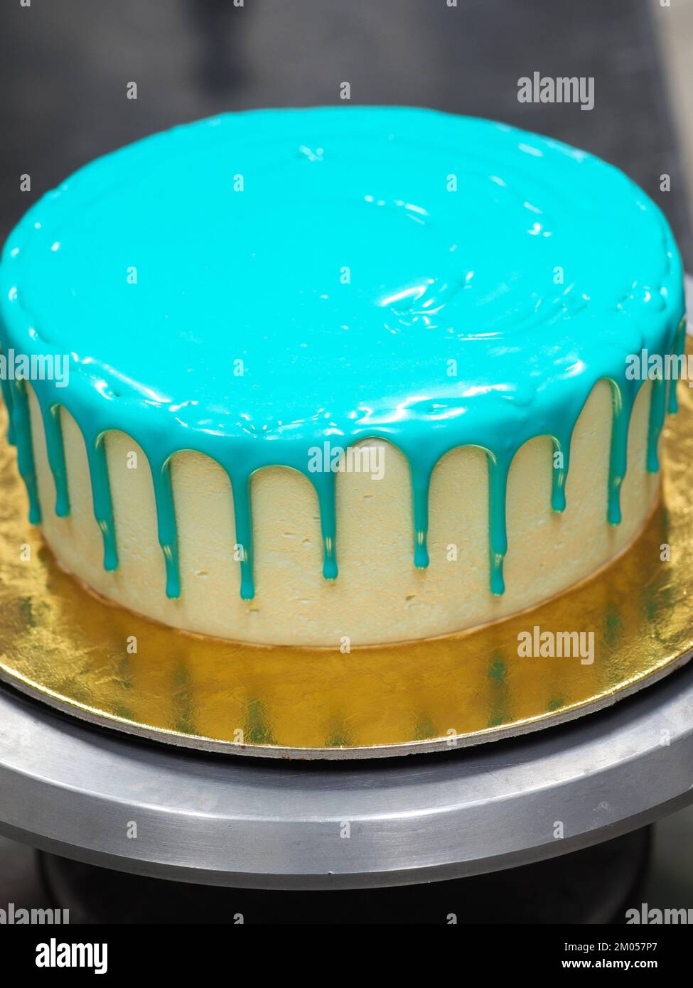 bag piping filling topping on frosted icing drip turquoise cake for ...